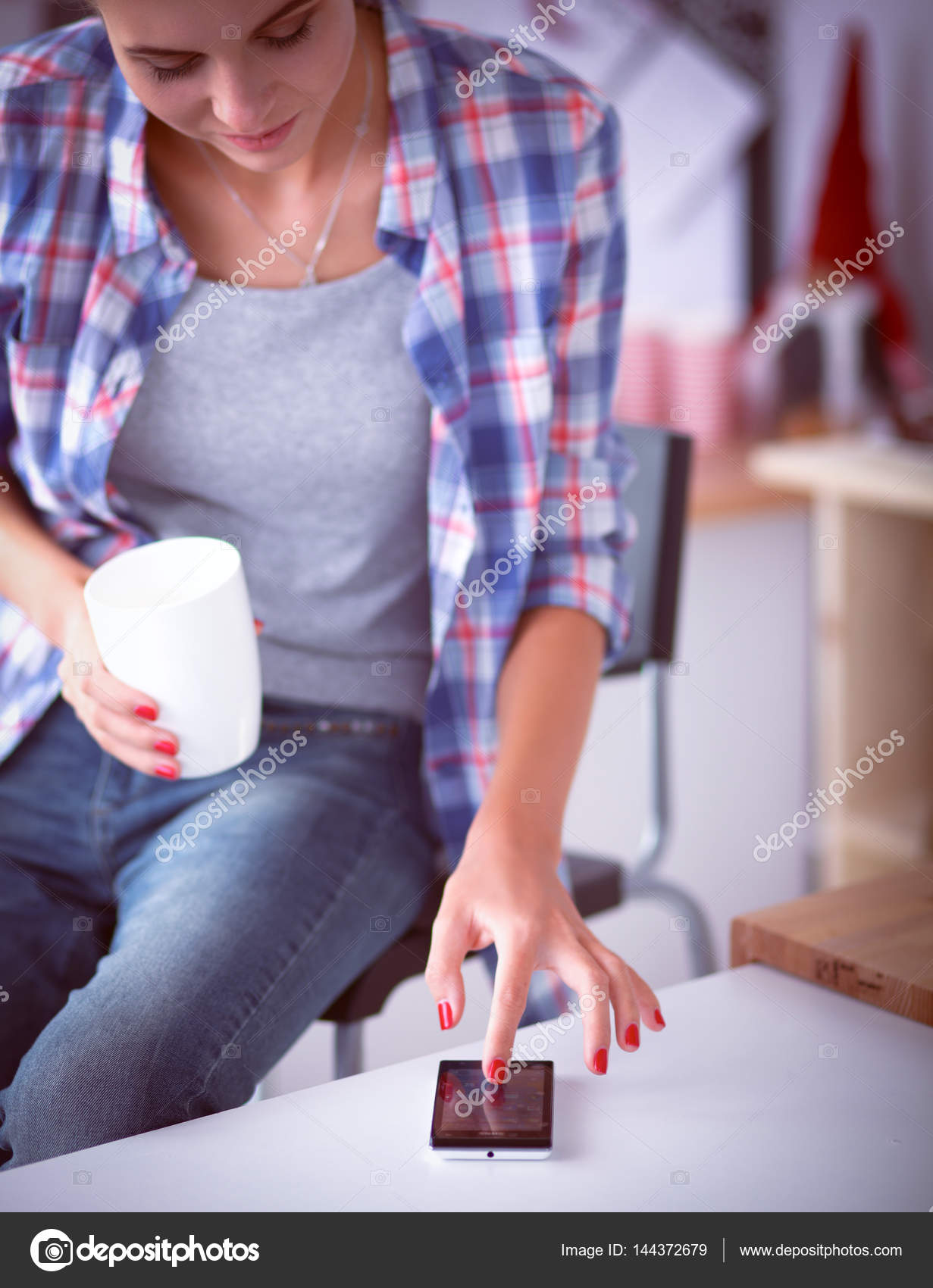 Smiling woman holding her cellphone in the kitchen — Stock Photo ... Smiling woman holding her cellphone in the kitchen — Stock Photo ...