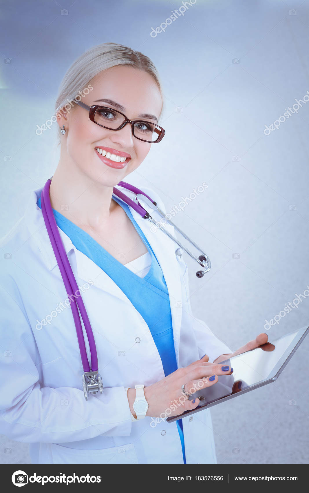Female doctor using a digital tablet and standing on white background ...