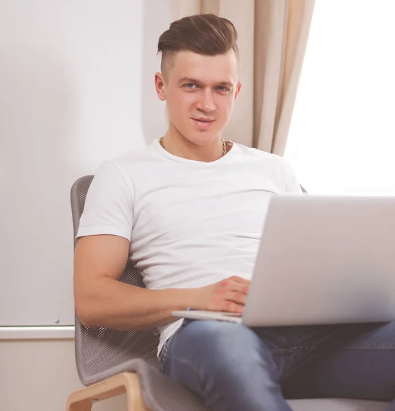 Young man sitting on chair with laptop Stock Photo by ©lenetssergey ...