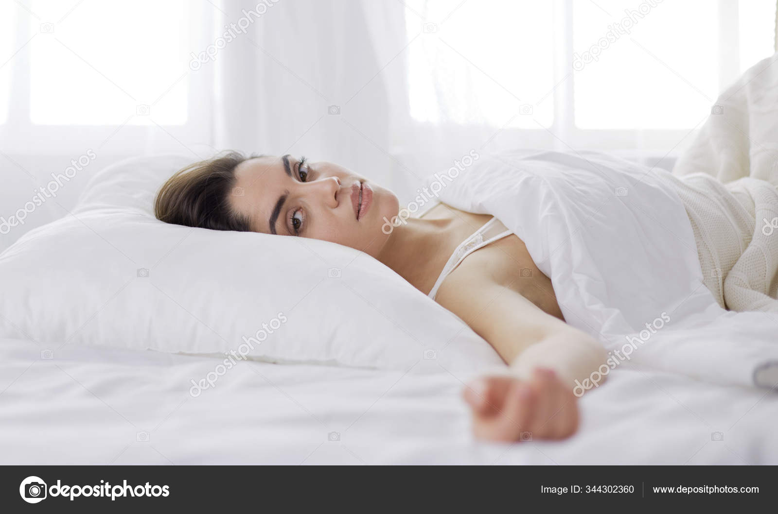 Pretty woman lying down on her bed at home Stock Photo by ©lenetssergey ...