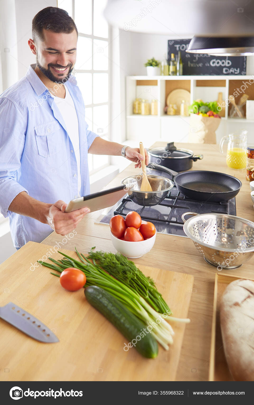 Man following recipe on digital tablet and cooking tasty and healthy ...
