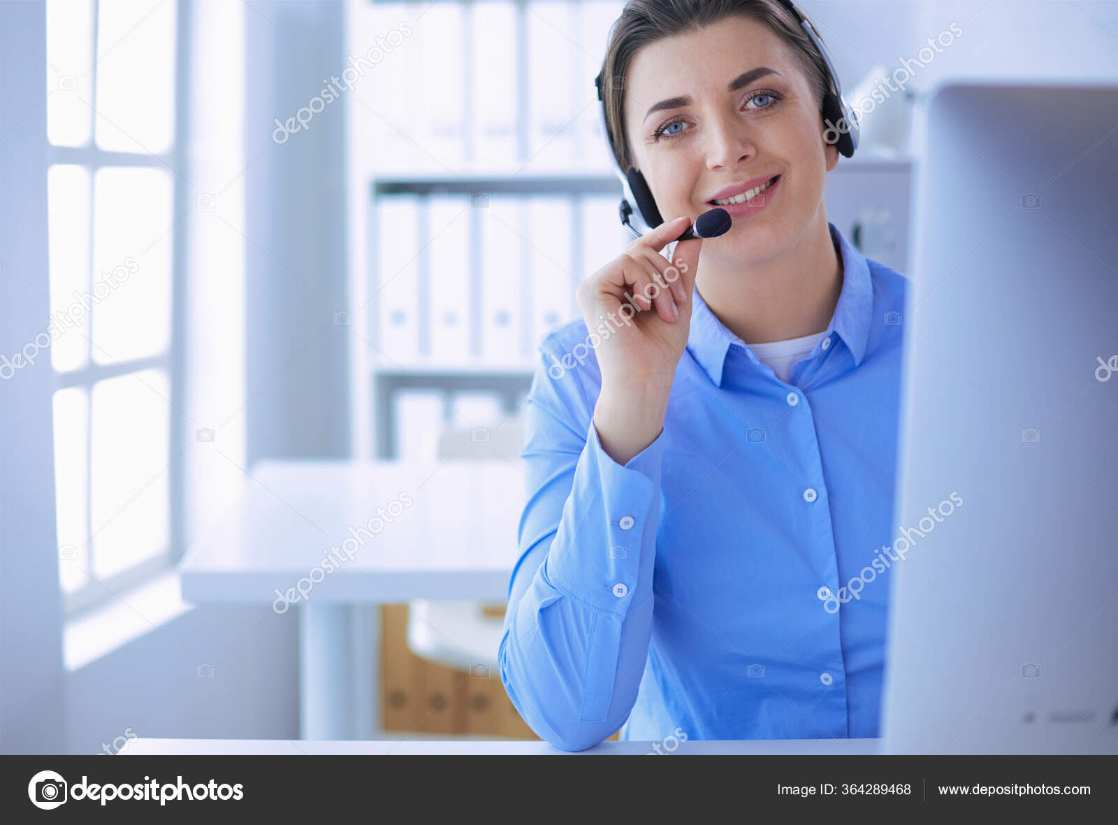 Serious pretty young woman working as support phone operator with headset in office Stock Photo ...