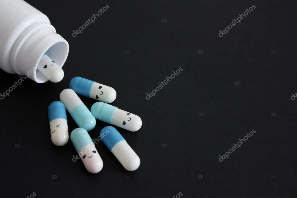 Antidepresivo blanco y azul píldoras sonrientes sobre fondo negro con ...
