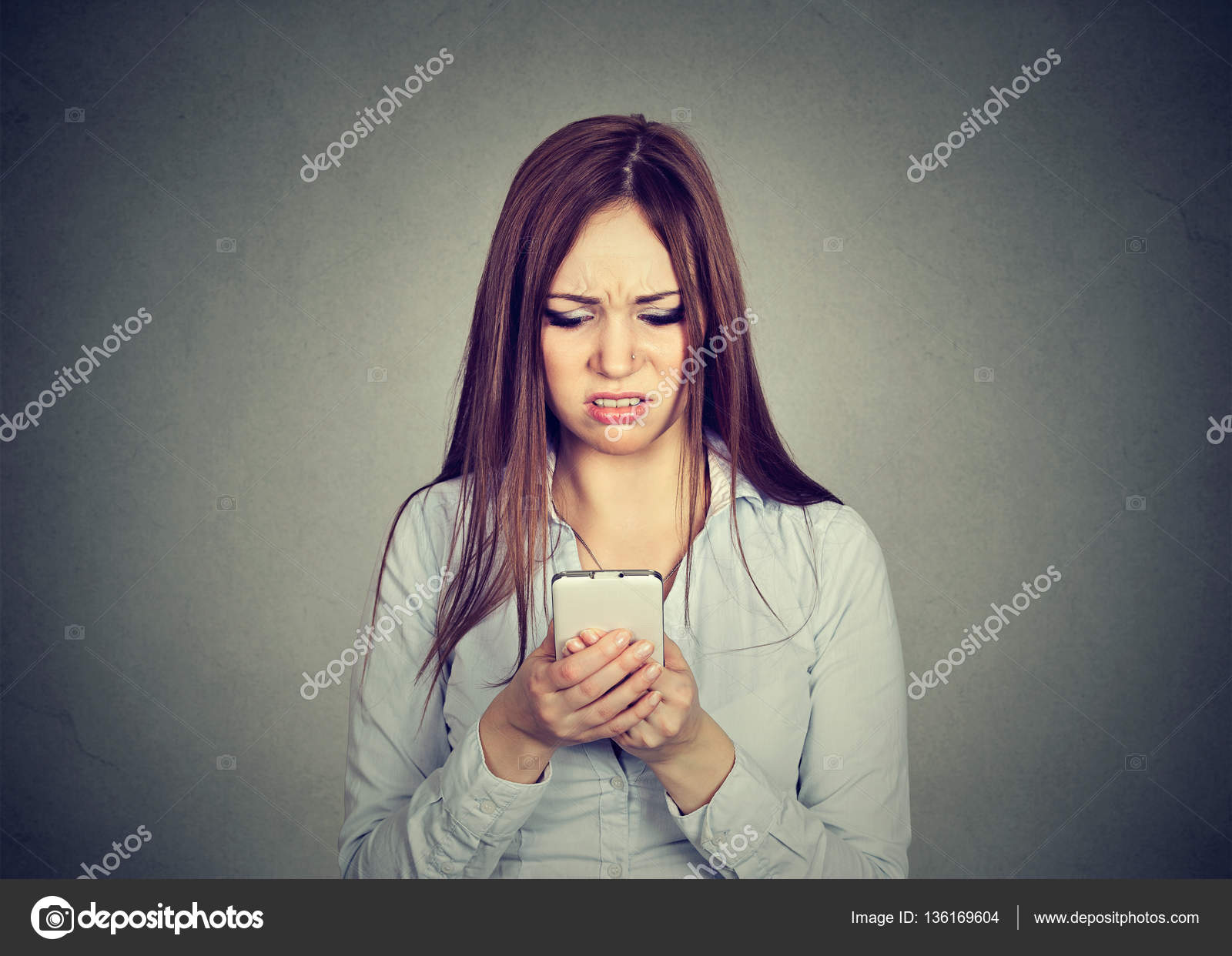 Upset Woman Looking At Cellphone Displeased With Message She Received