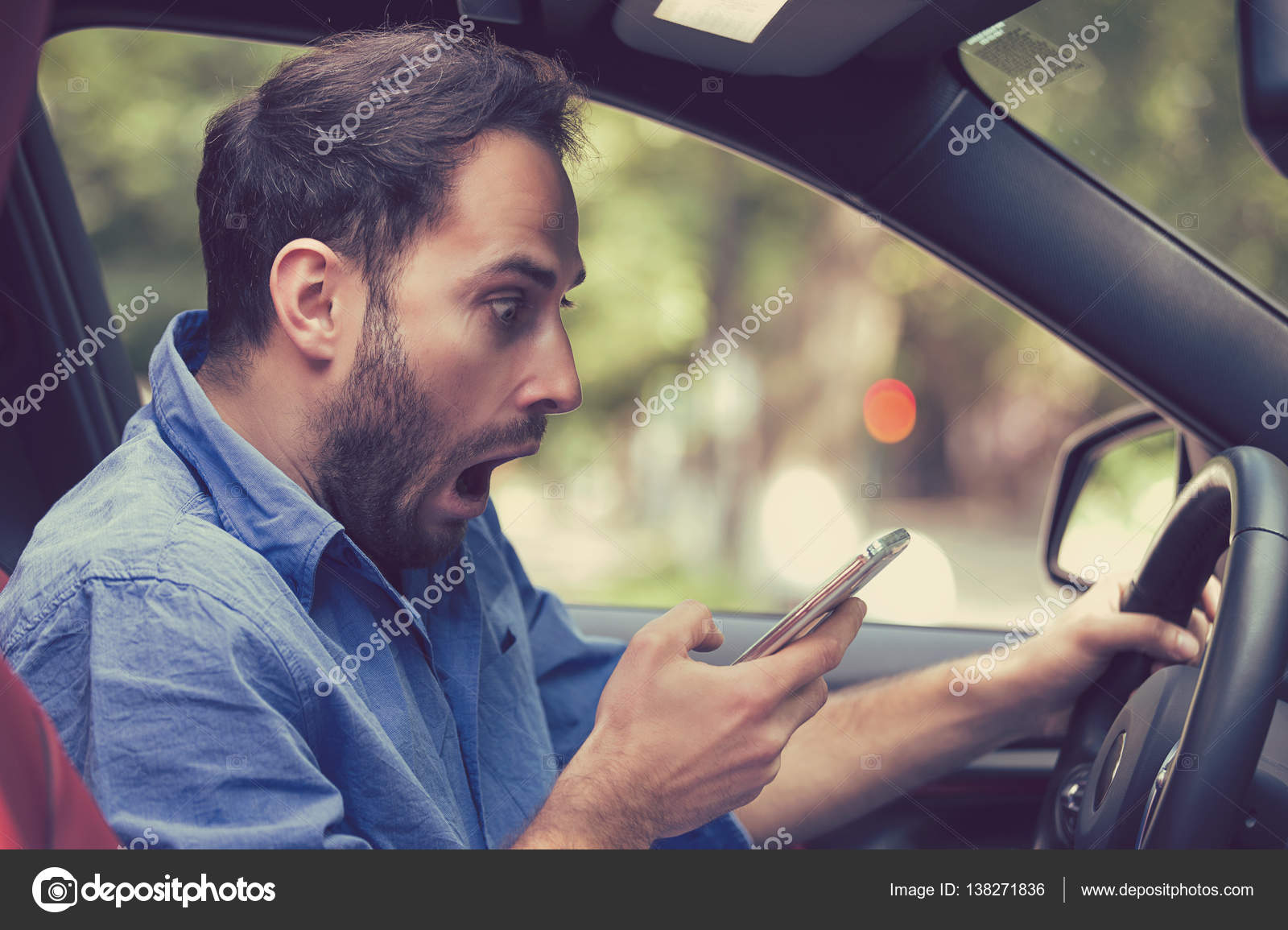 Man sitting inside car with mobile phone texting while driving Stock ...