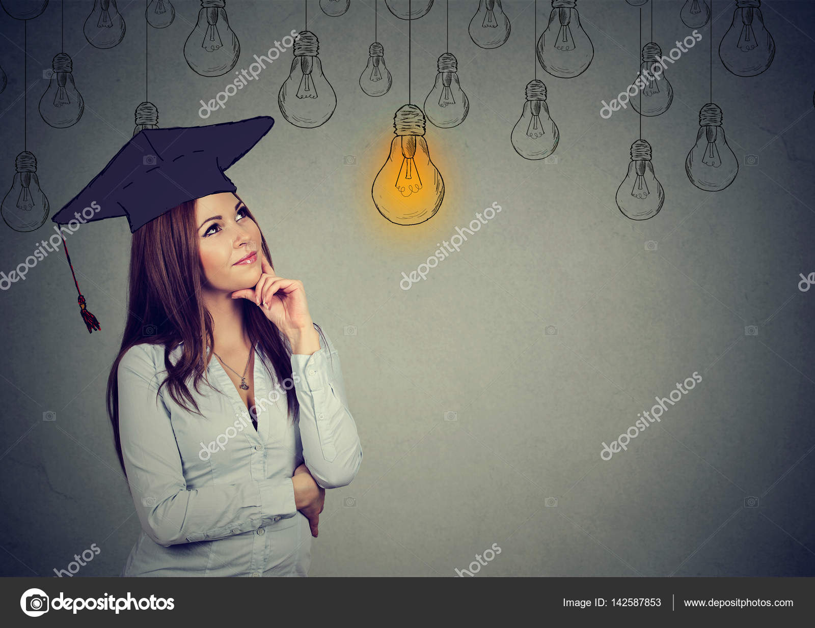 Thoughtful graduate student looking up at bright light bulb — Stock ...