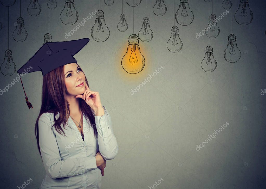 Estudiante graduado reflexivo mirando hacia arriba en la bombilla ...