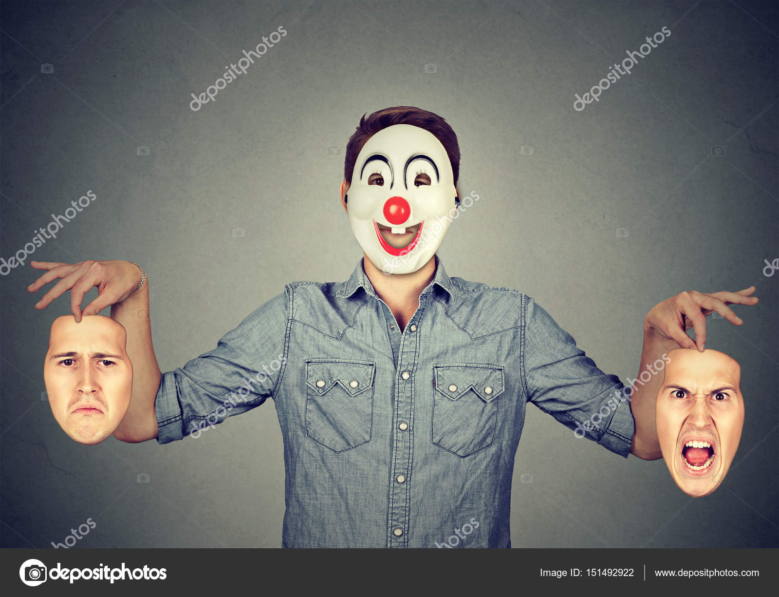 Man in happy clown mask holding two faces expressing anger and sadness ...