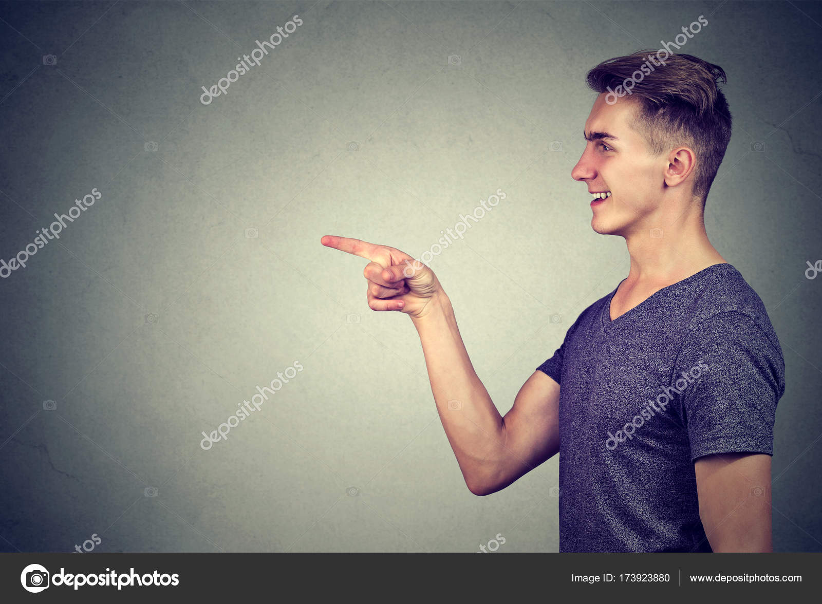 Side profile of a laughing young man pointing finger at someone — Stock ...