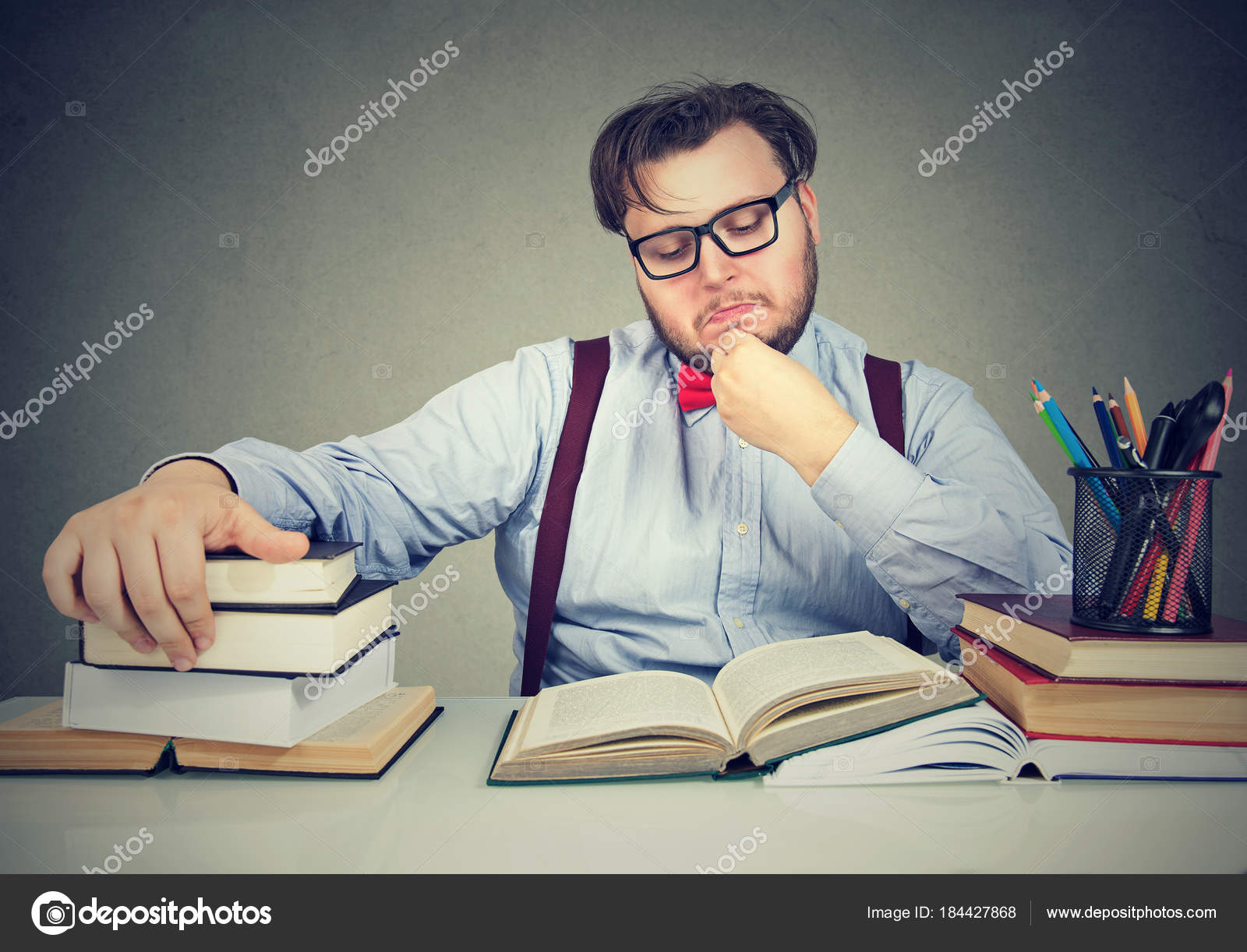Smart man reading plenty of books Stock Photo by ©SIphotography 184427868