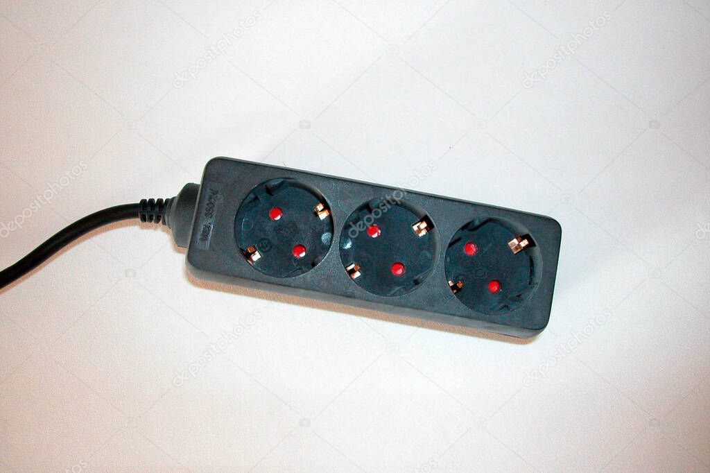 una toma de corriente blanca de 220 voltios sobre fondo negro 2023