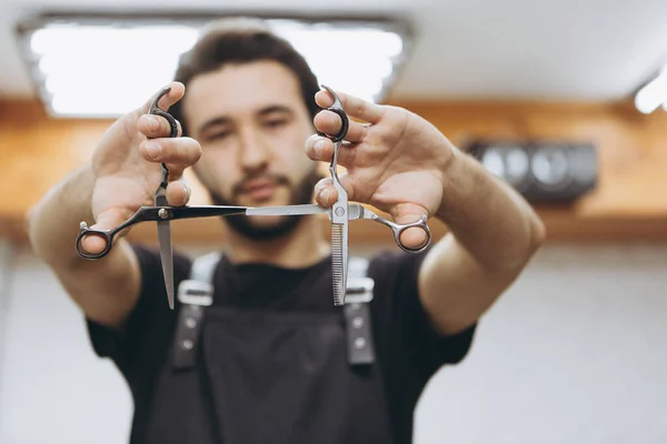 professional barber tool: sharpened scissors held by a haircut master ...