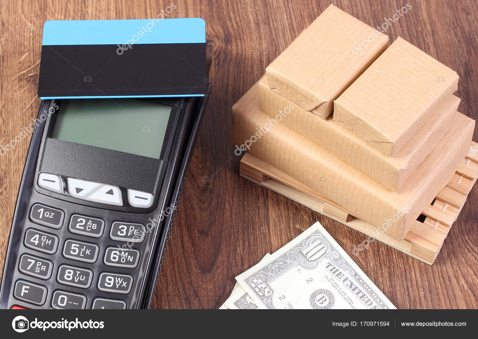 Payment terminal with credit card, currencies dollar and wrapped boxes ...