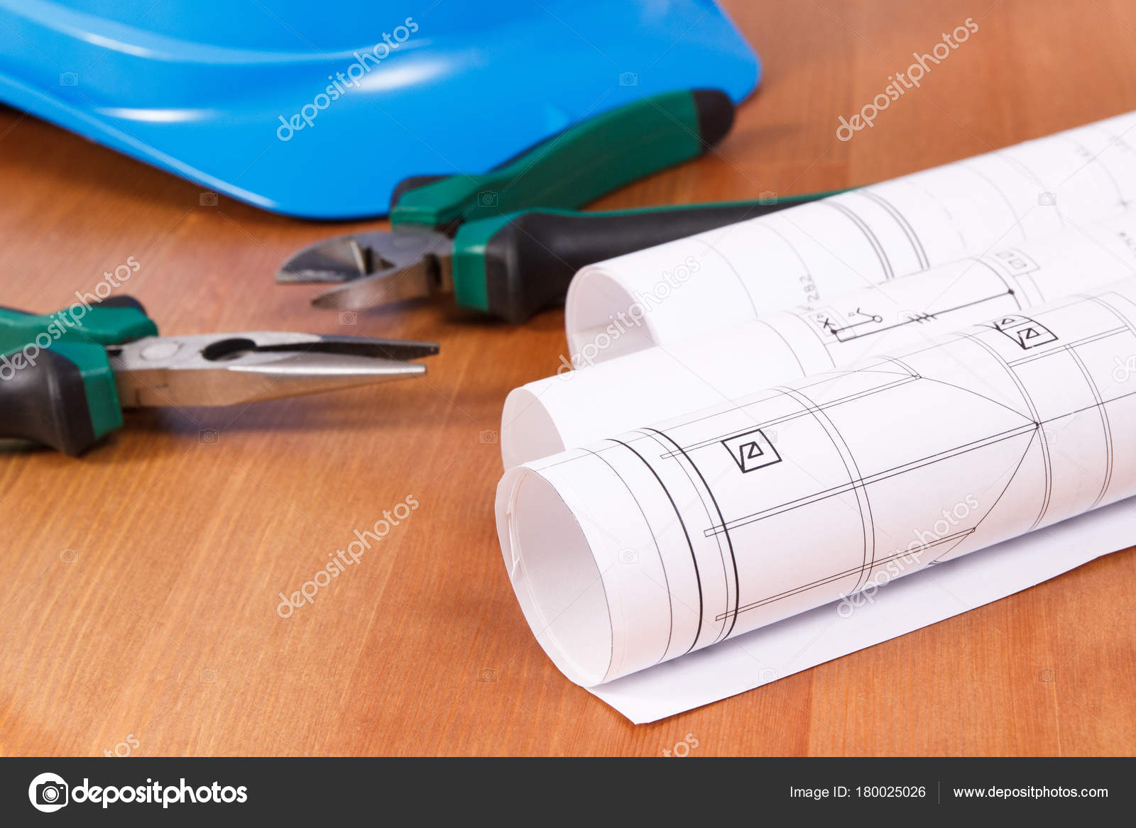 Rolls of electrical construction drawings, protective helmet and work ...