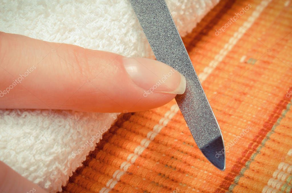 Mujer puliendo uñas usando lima de uñas. El cuidado de las manos y ...