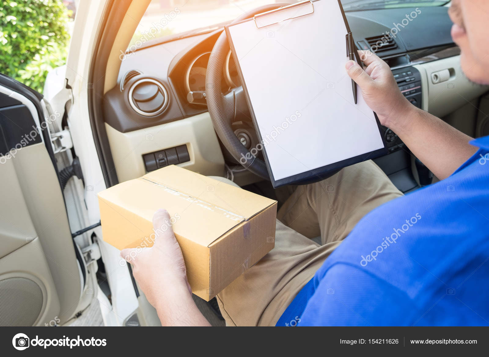 Delivery man checking document list Stock Photo by ©snowing 154211626