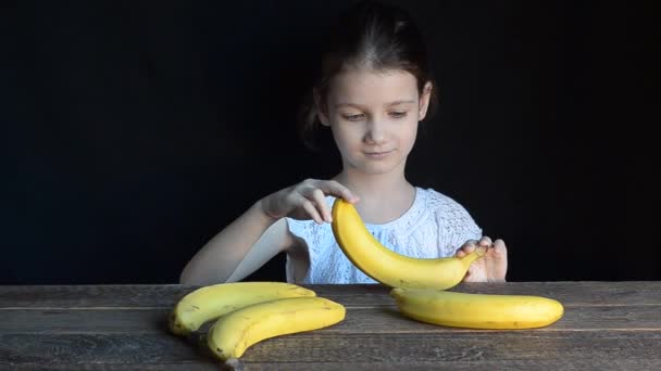 Girl playing with bananas. Black background — Stock Video ...