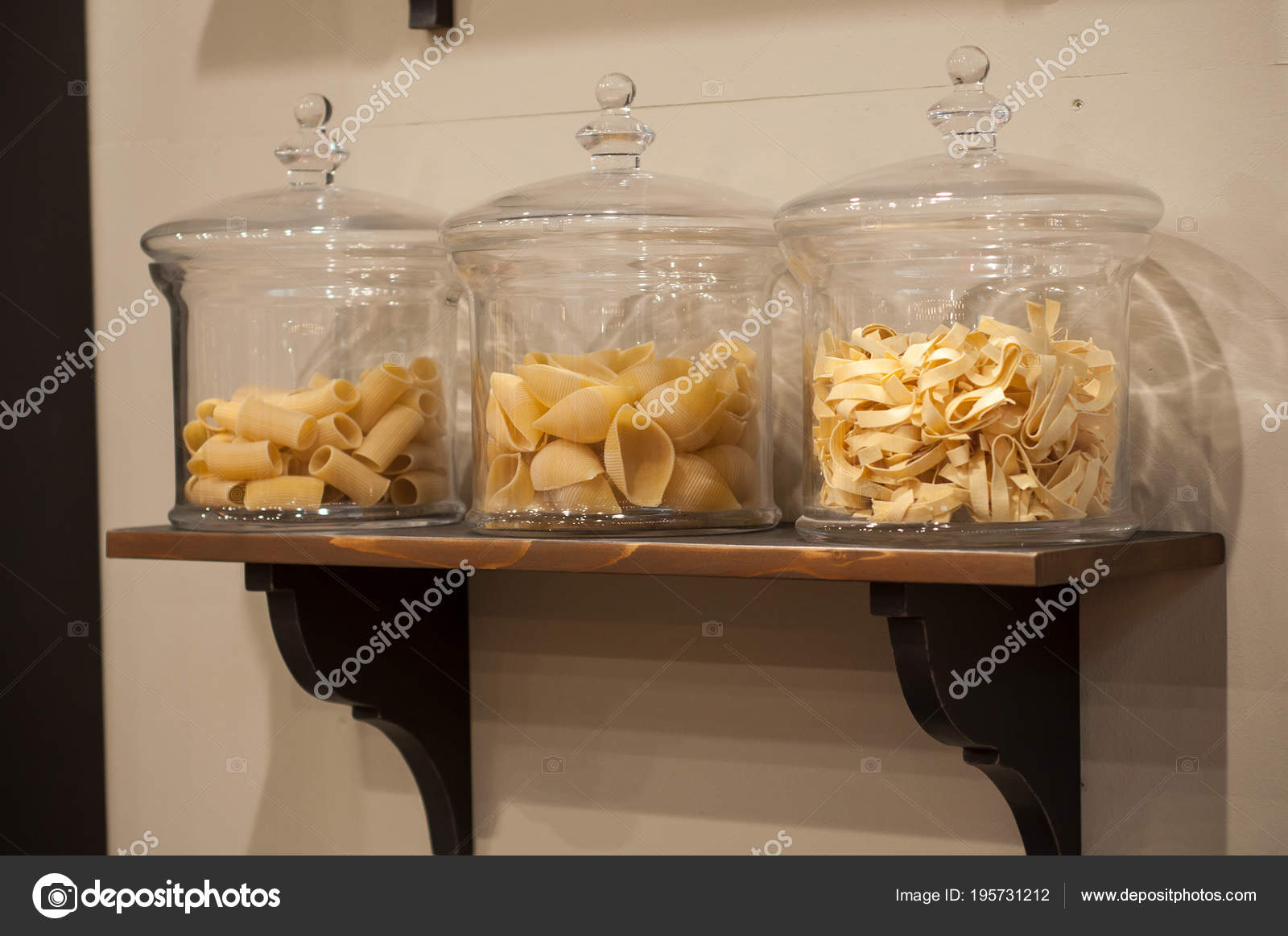 Various pasta in glass containers on the wall Stock Photo by ...