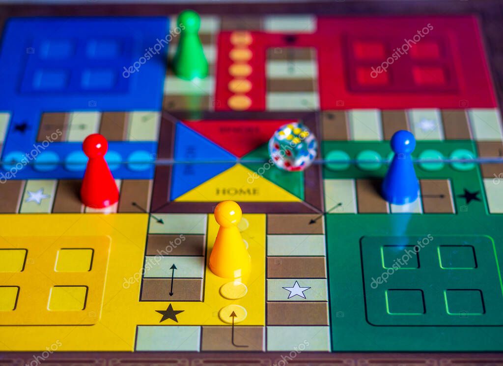 Piezas y un dado en un juego de mesa Ludo 2024