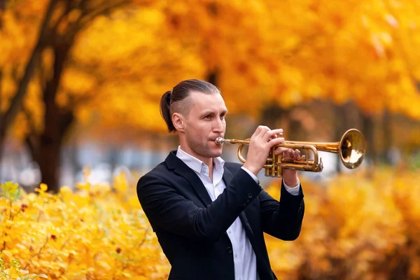 young European handsome trumpeter in formal clothes playing his musical ...