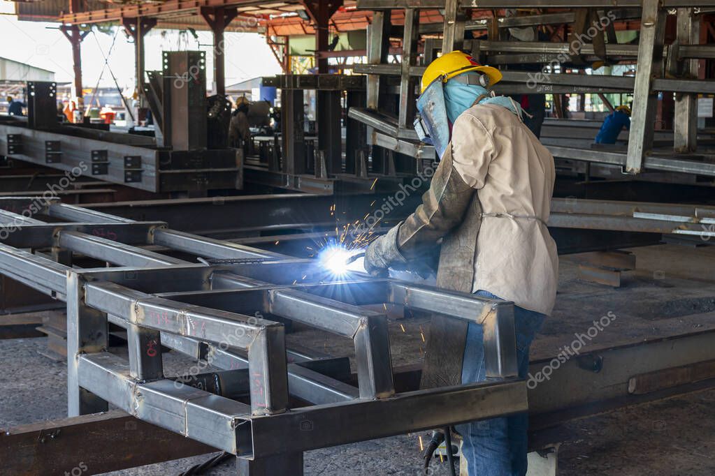 El soldador está soldando un trabajo de la estructura de acero con la ...