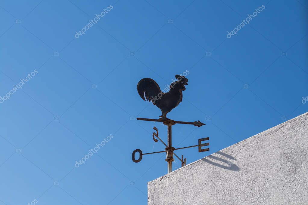 Gallo de hierro negro en una esquina de un techo de un edificio con ...