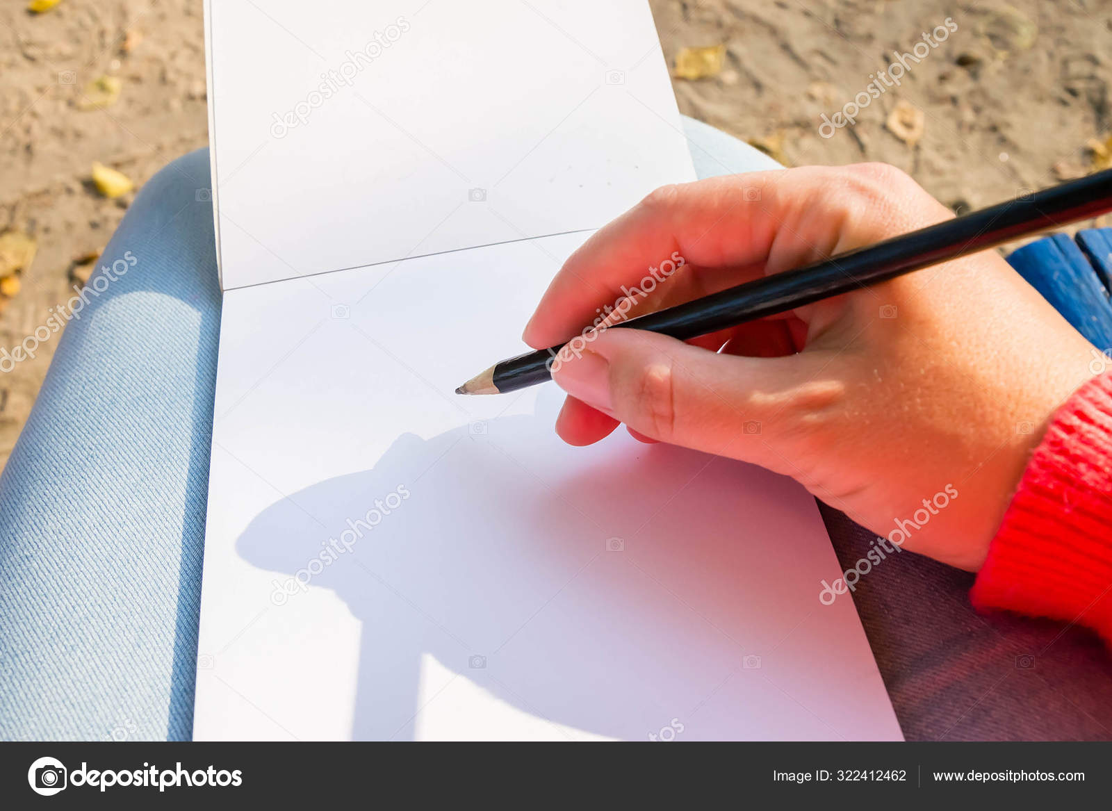 A blank notepad for planning, summing up. Hand holds pencil. She will ...