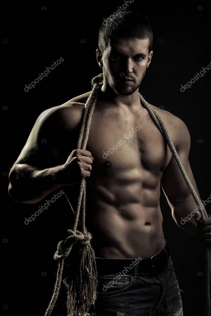 Muscular man with rope — Stock Photo © Tverdohlib.com #129785806
