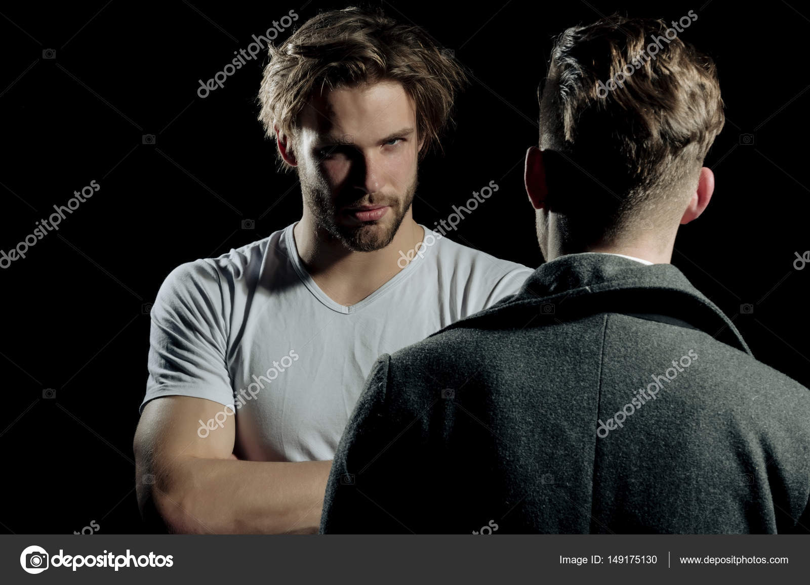 Two handsome men standing with faces opposite Stock Photo by ...