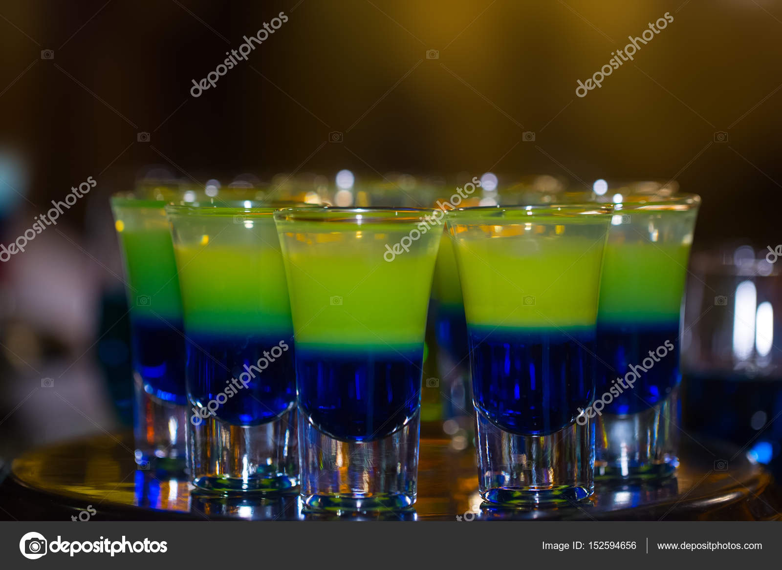 Blue and yellow layered shooters or cocktails in shot glasses, Stock ...