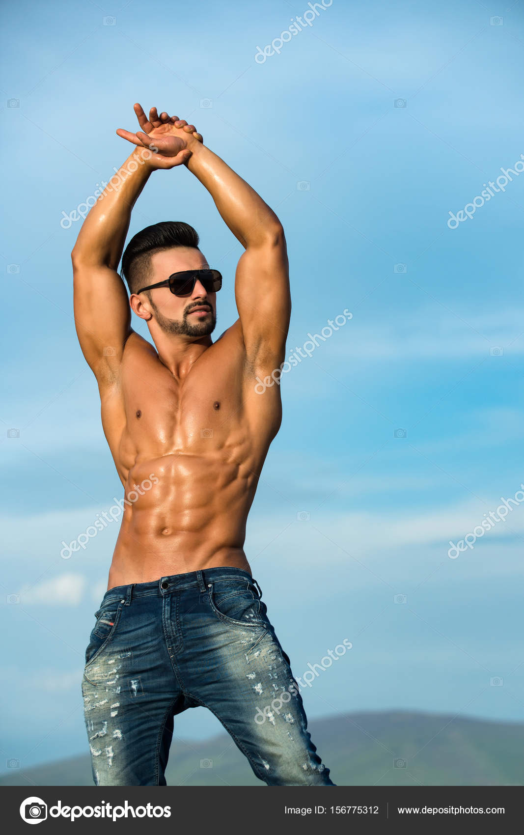 Macho man with muscular body in sunglasses on blue sky Stock Photo by ...