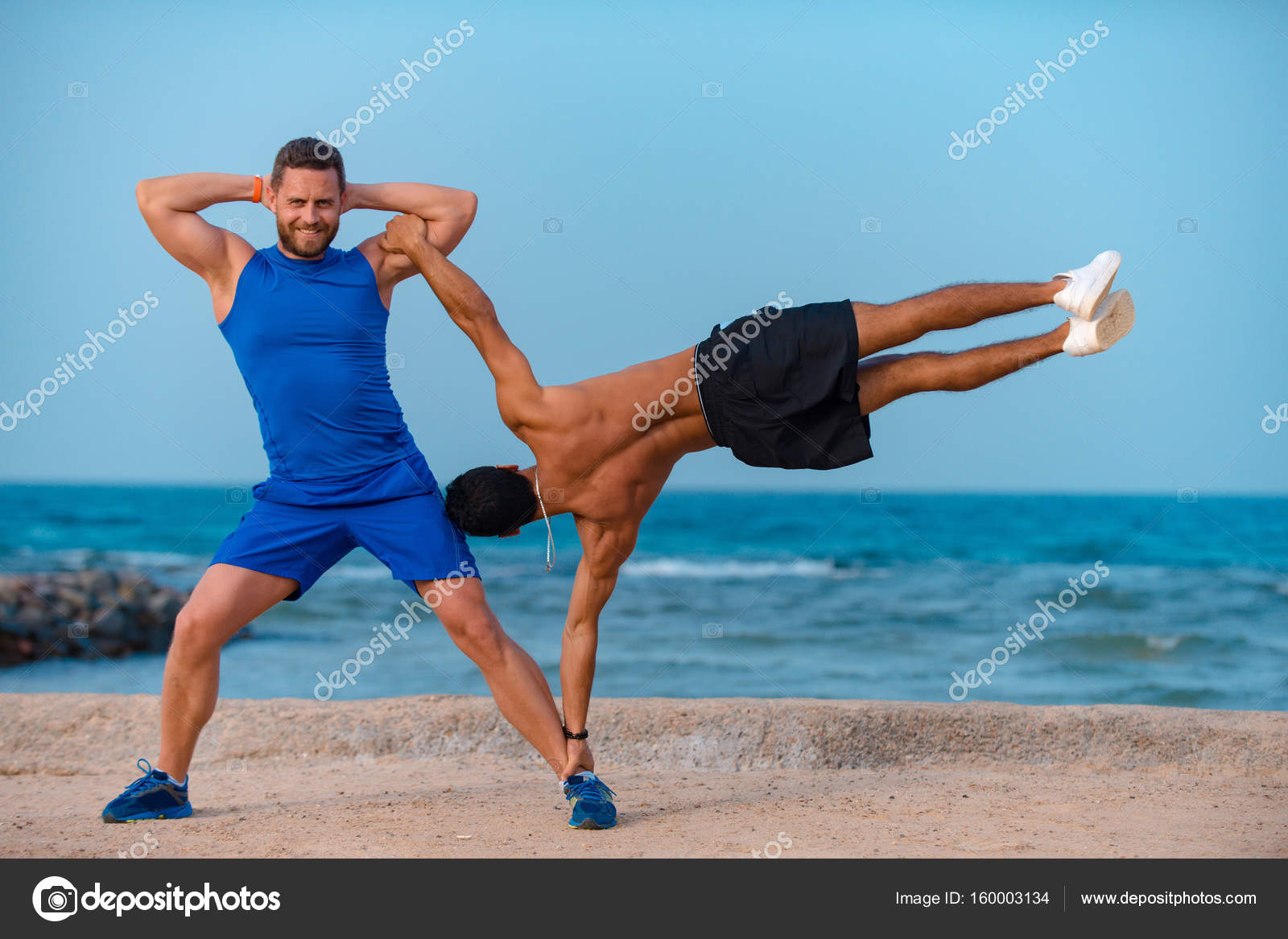 Two men handsome athletic boys doing acrobatic trick at beach — Stock ...