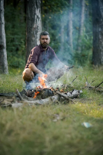 Man hiker make fire in forest - Stock Image - Everypixel