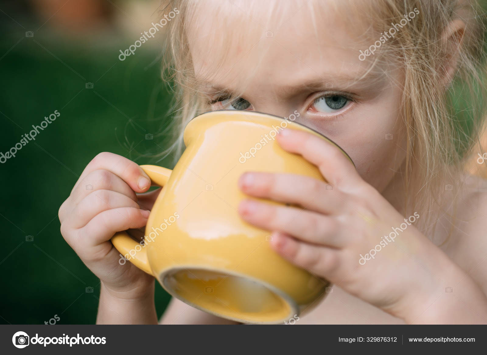 Girl drinking something. Water. Juice. Milk. Happy child in summer in ...