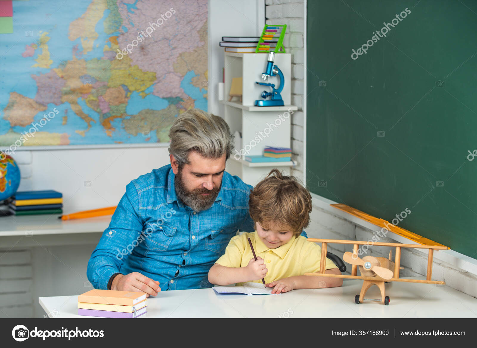 Father teaching son. Learning concept. Pupil learning letters and ...