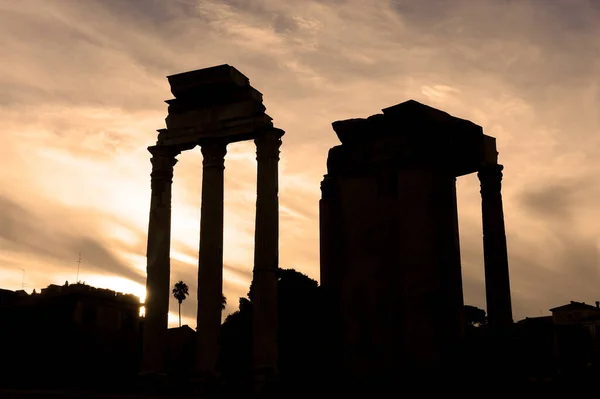 Roman ruins and backlit columns at sunset in the Roman Forum in Rome ...