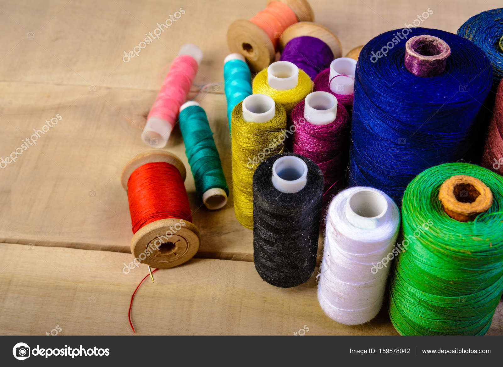 Coils with threads of different colors on a wooden table — Stock Photo ...