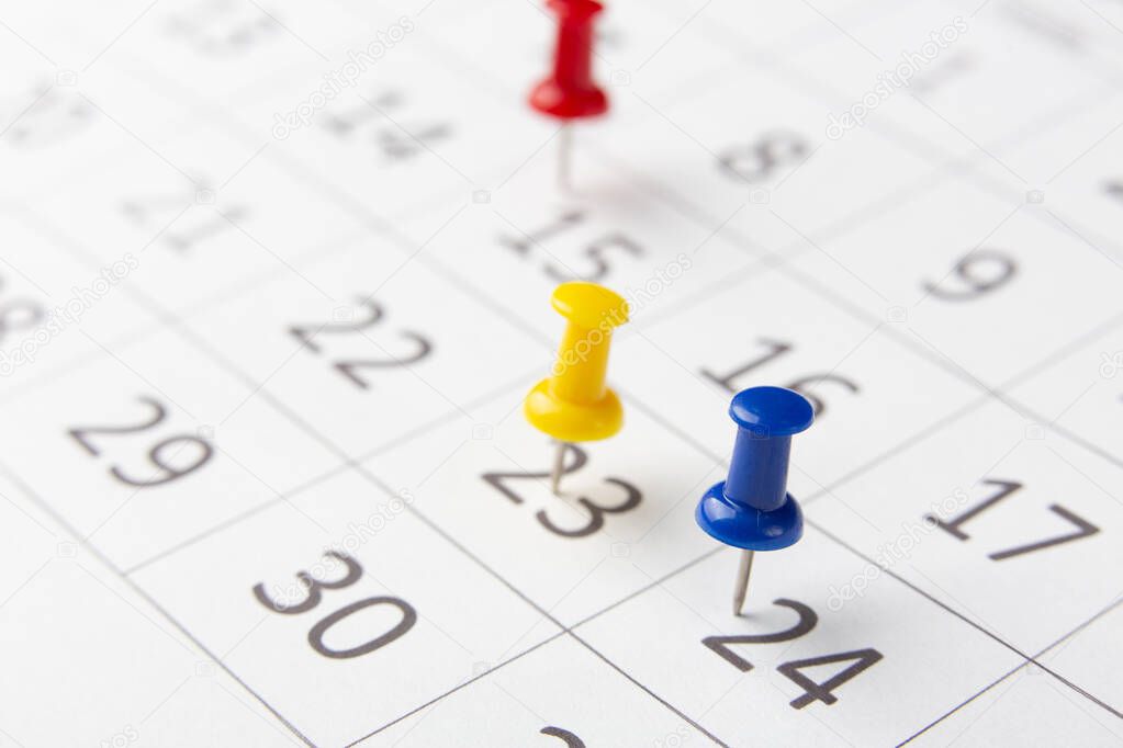 Calendario con diferentes fechas marcadas con chinchetas de colores 2023