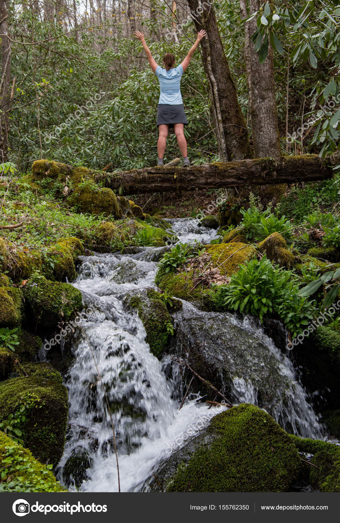 Woman Stands on Log Bridge and Power Poses — Stock Photo © kvddesign ...