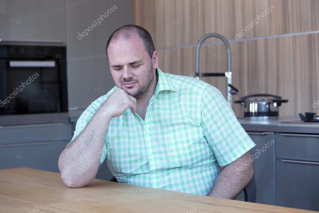 Overweight man sitting at kitchen table with eyes closed Stock Photo by ...
