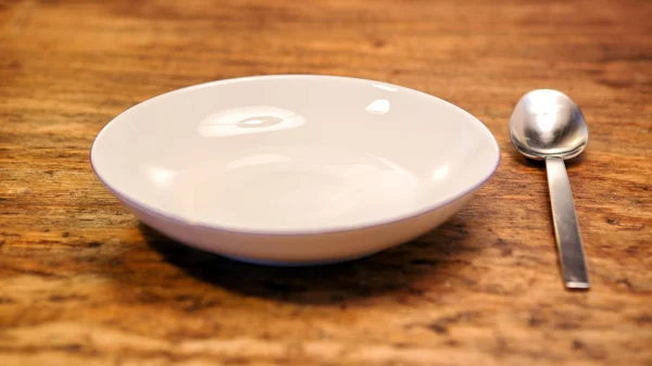 A plate of milk and a spoon close up on white table. Stock Photo by ...