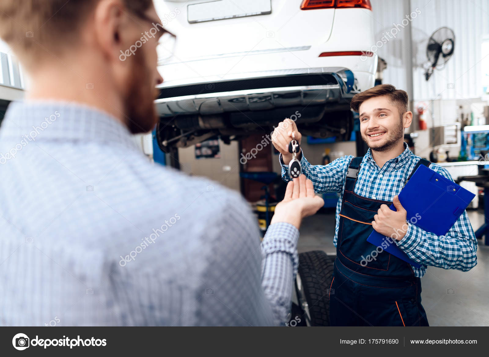 The man takes his car from the auto service. The mechanic transfers the ...