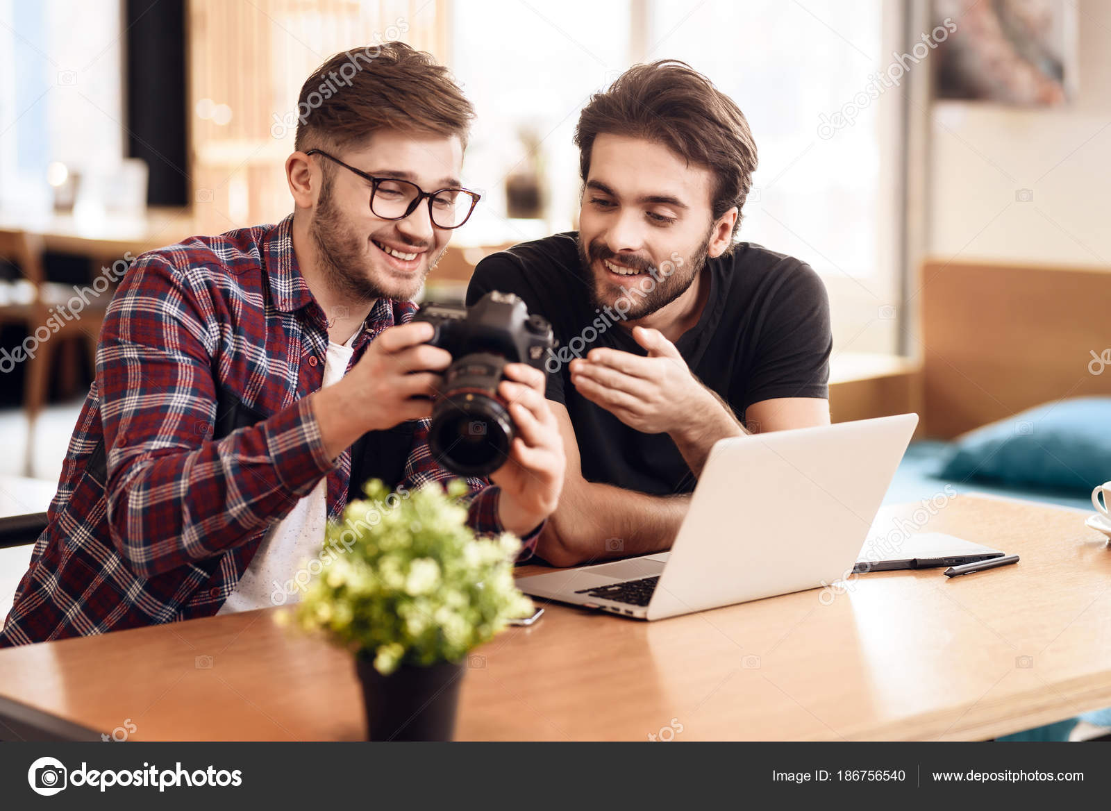 Two freelancer men looking at photos at laptop at desk. — Stock Photo © vadimphoto1@gmail.com ...