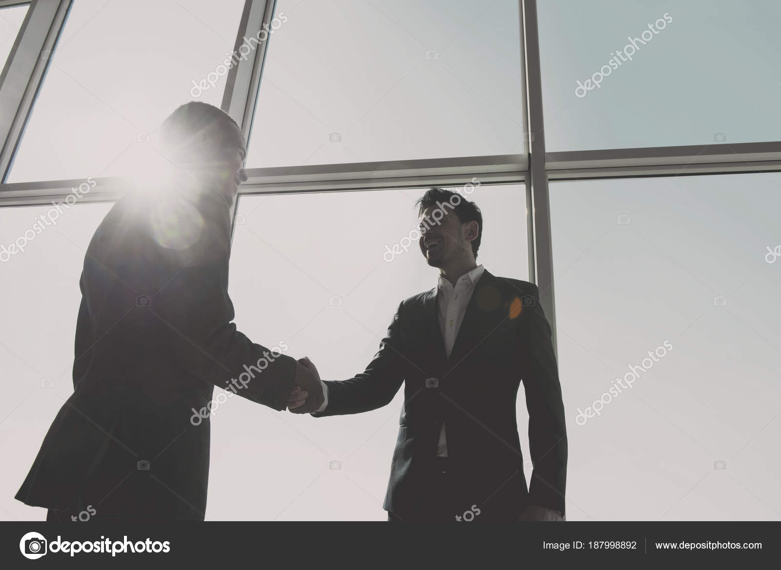 View from below of two young businessmen are standing in modern office ...