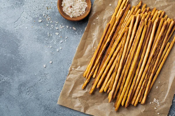 Salted bread sticks or long crunchy salty pretzel sticks on parchment ...