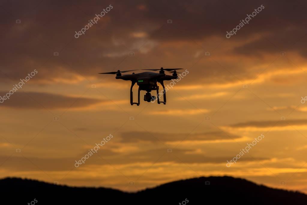 Silueta de drones volando en el paisaje del atardecer 2022