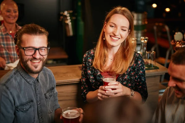Group of friends drinking beer, chatting and having good time at pub ...