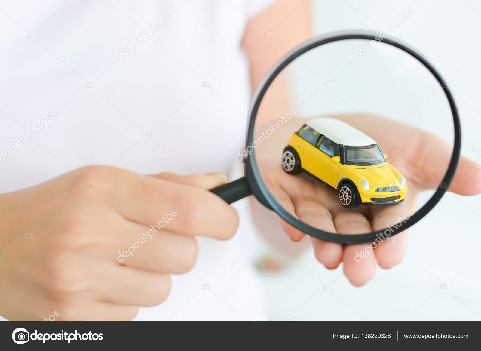 Car model under magnifying glass in woman hand suggesting car search ...