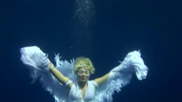 Young girl model underwater white angel costume on blue background in ...