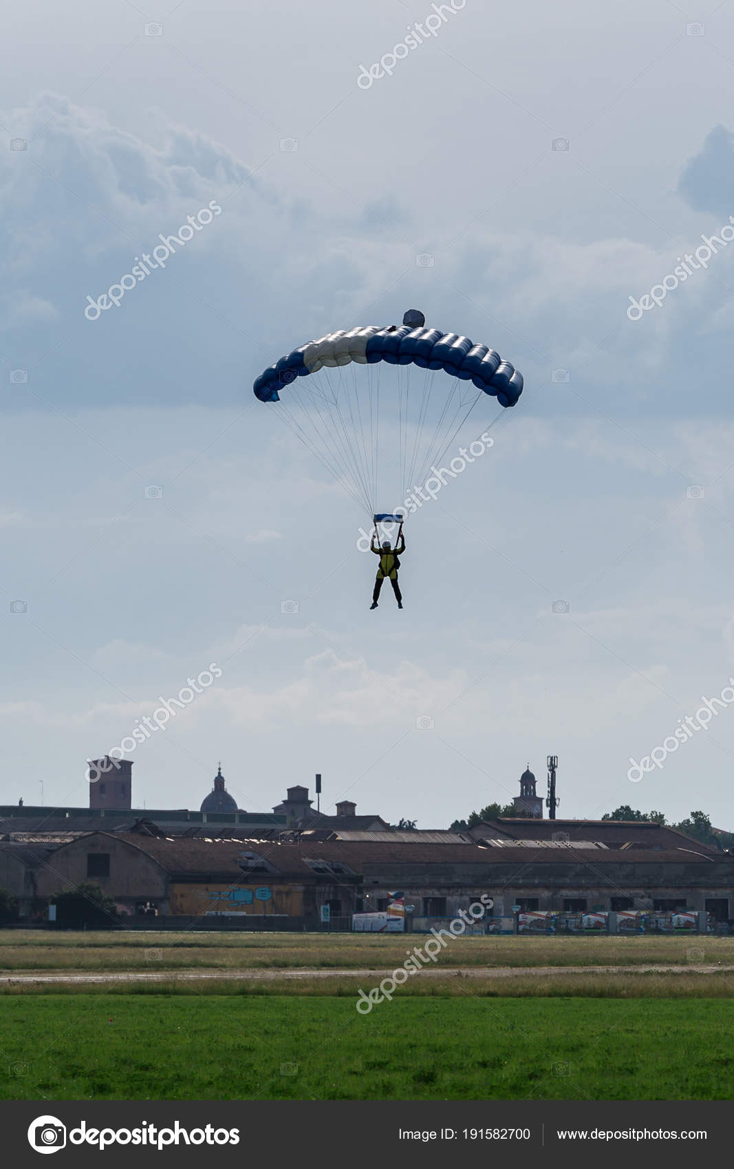 Parachutist with Blue Parachute near to the Ground Preparing for ...